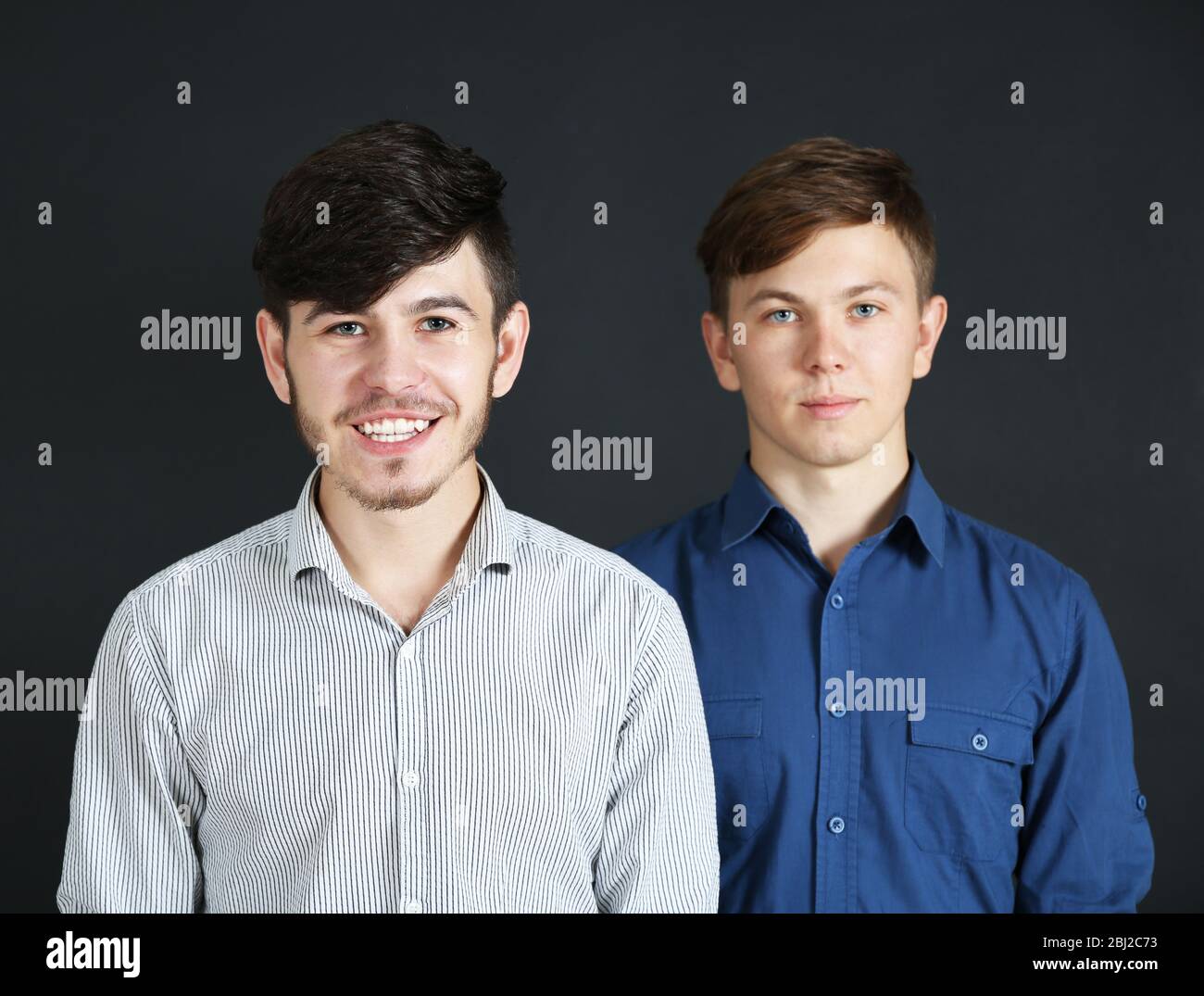 Two brothers on dark background Stock Photo - Alamy