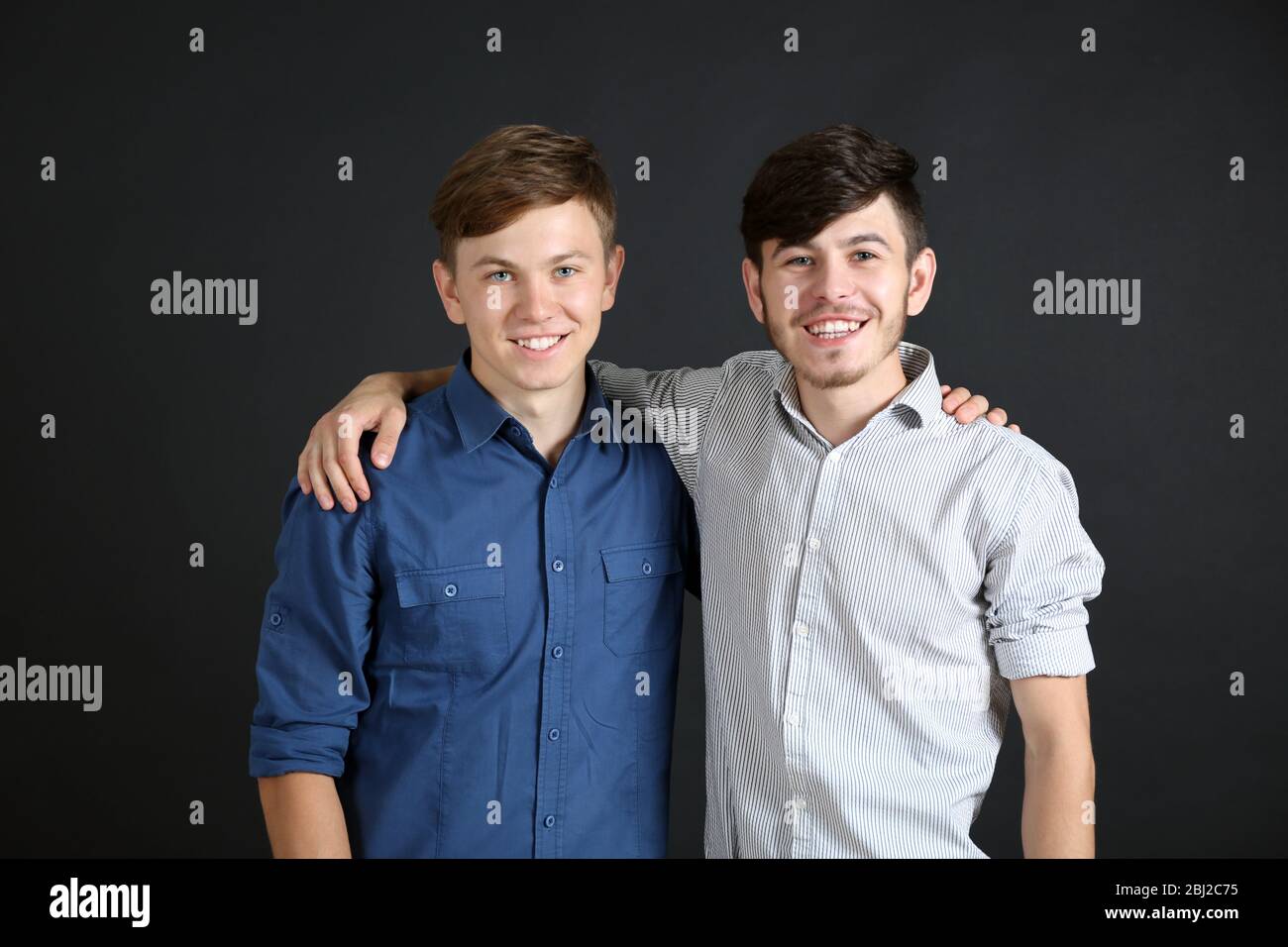 Two brothers on dark background Stock Photo - Alamy