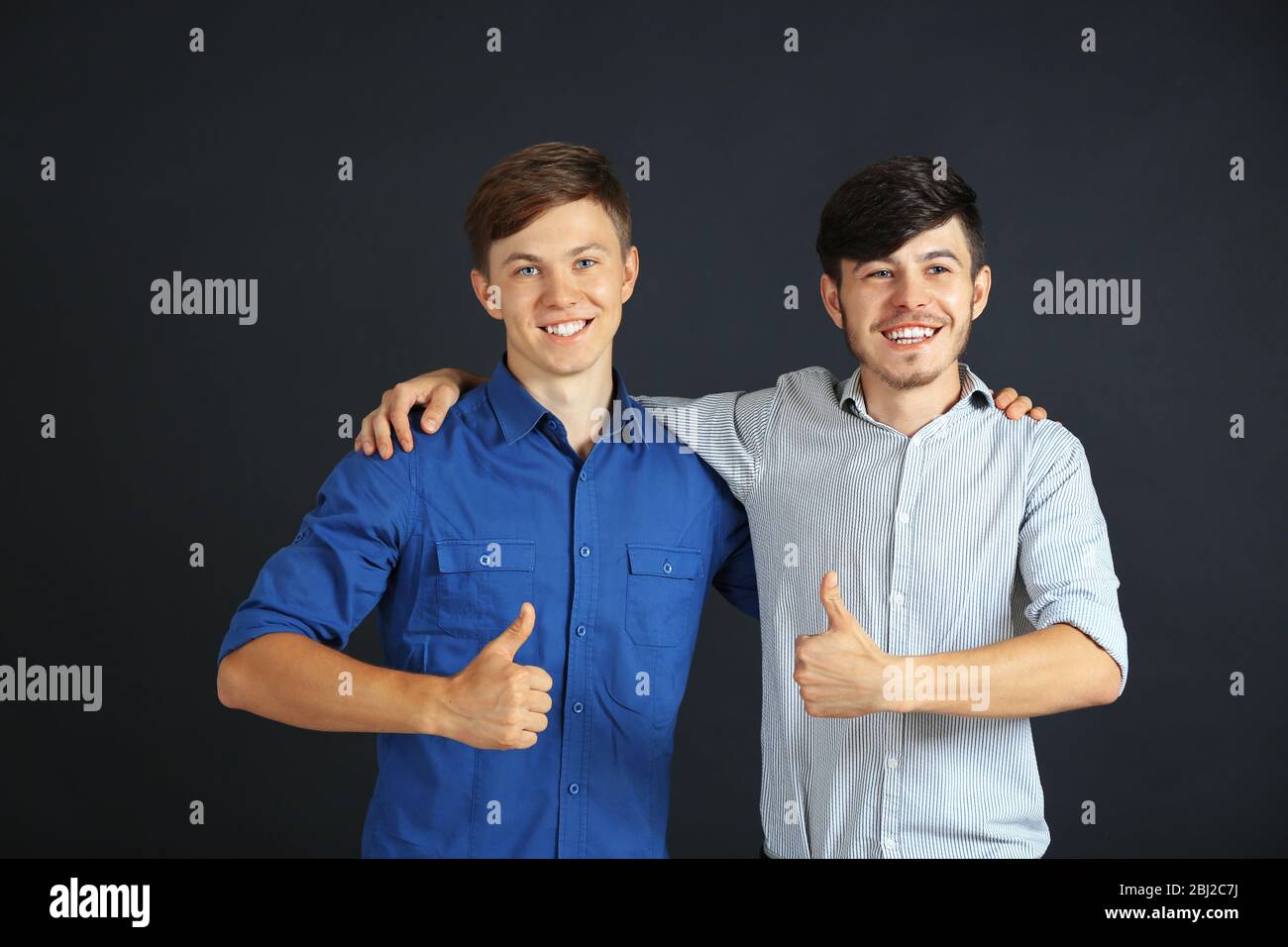 Two brothers on dark background Stock Photo - Alamy