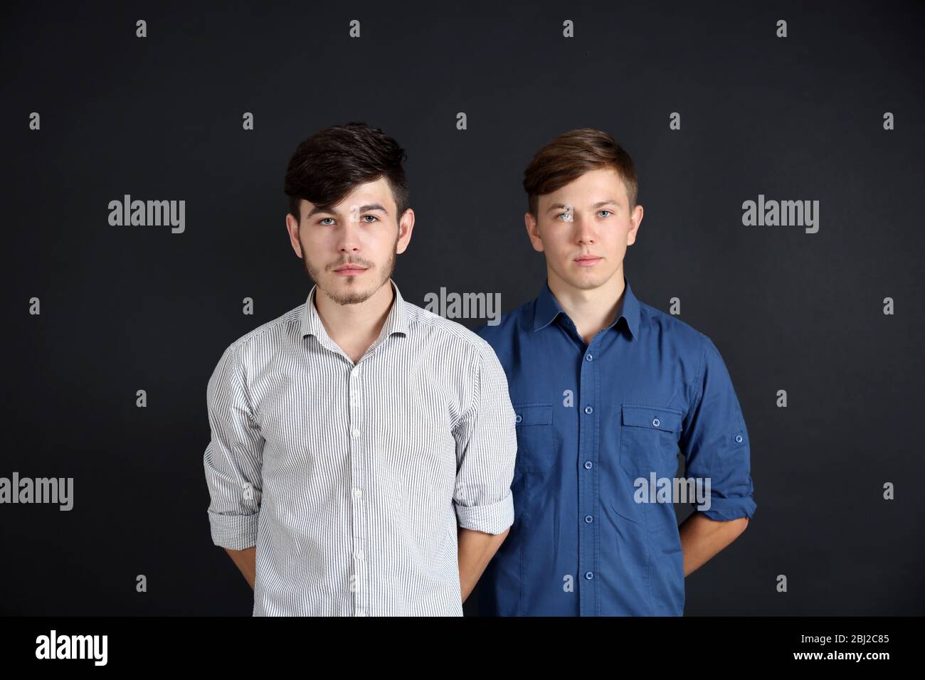 Two brothers on dark background Stock Photo - Alamy