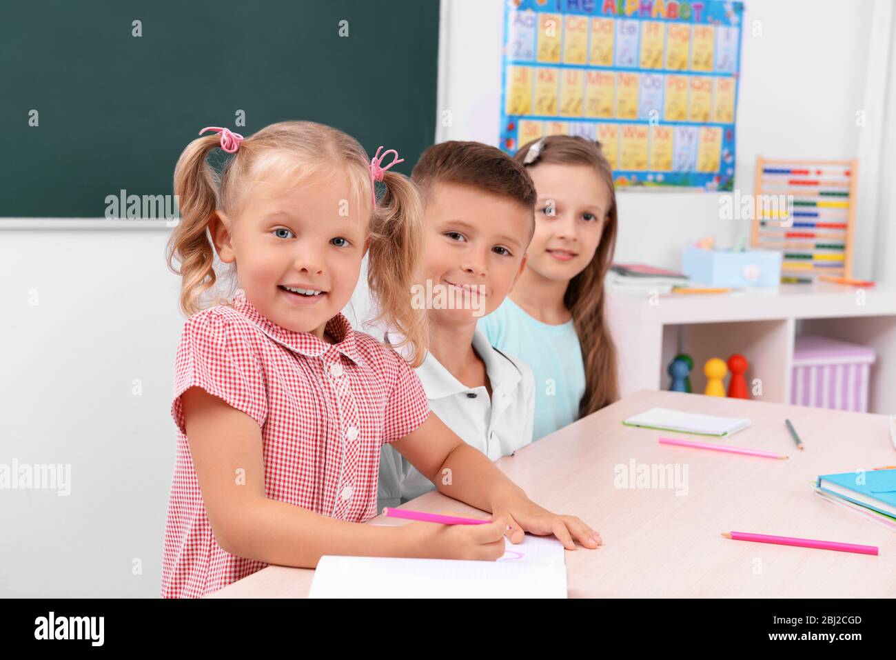 Group of children at the desk in classroom Stock Photo - Alamy