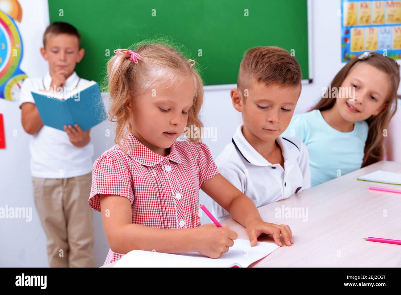 Group of children at the desk in classroom Stock Photo - Alamy