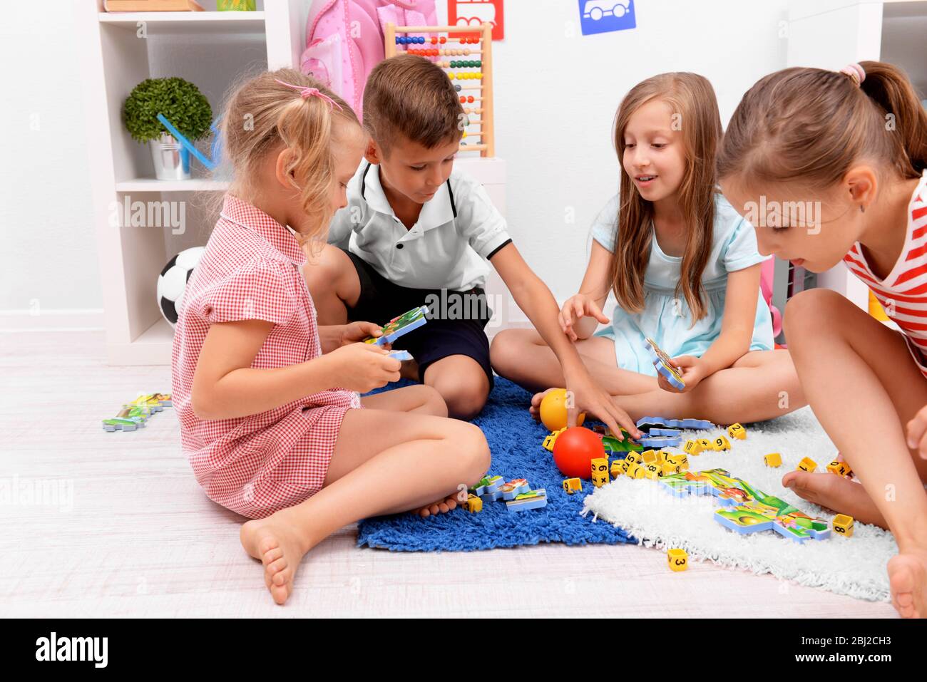 Group of children playing on floor in classroom Stock Photo - Alamy