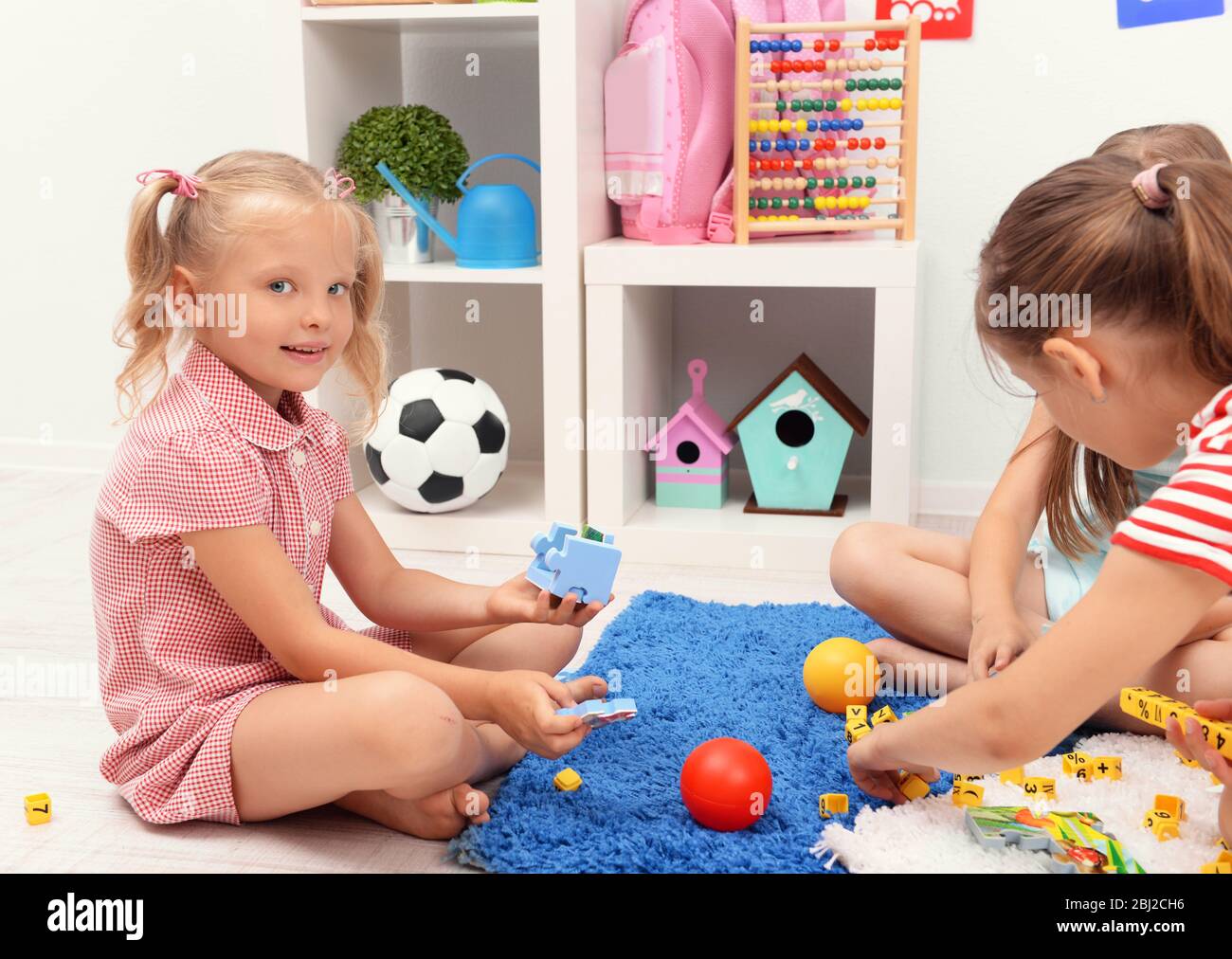 Group of children playing on floor in classroom Stock Photo - Alamy