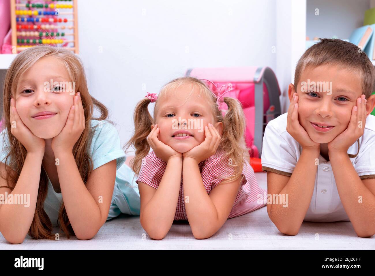 Row of children on floor in classroom Stock Photo - Alamy