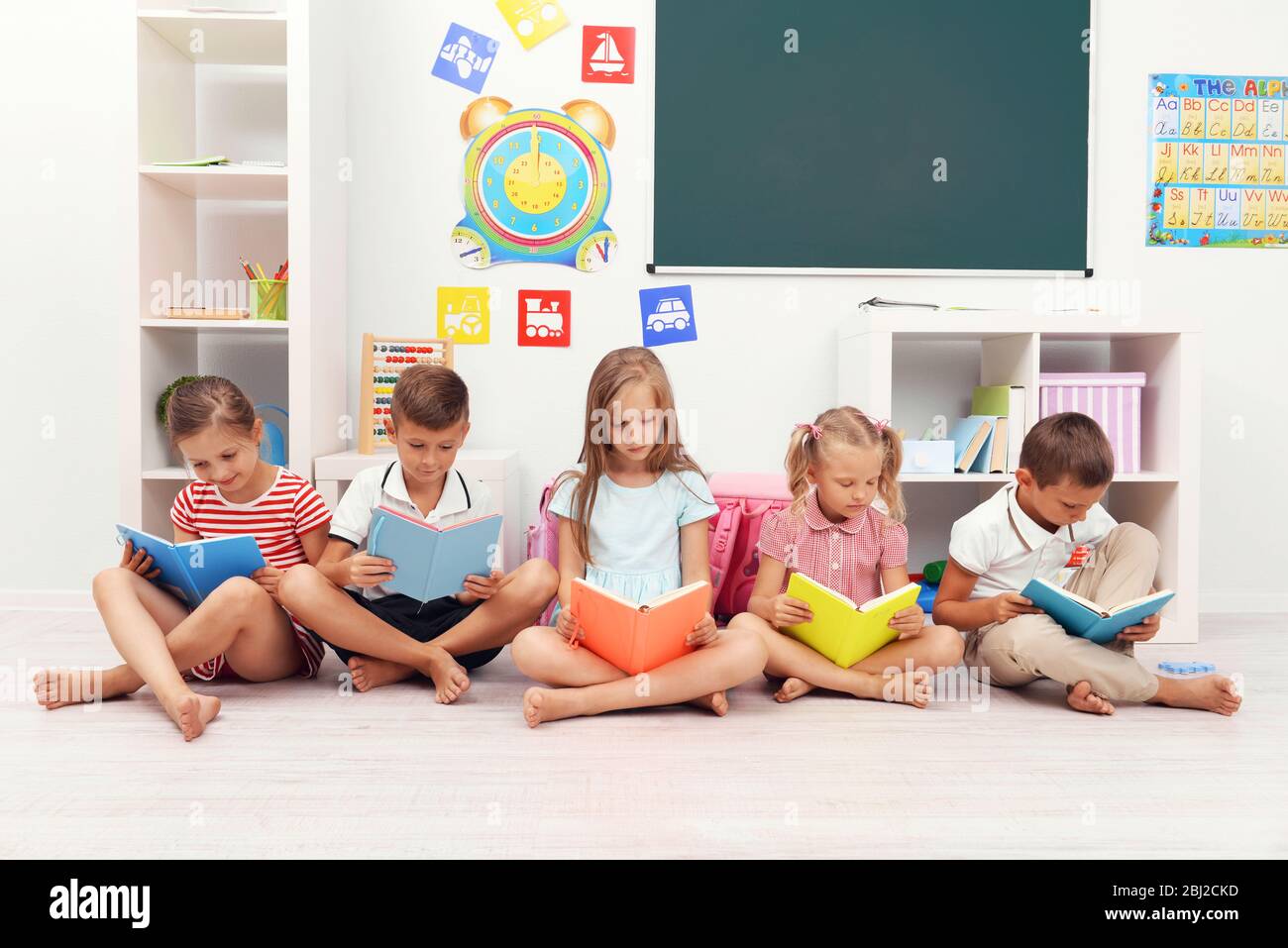 Row of children reading hi-res stock photography and images - Alamy