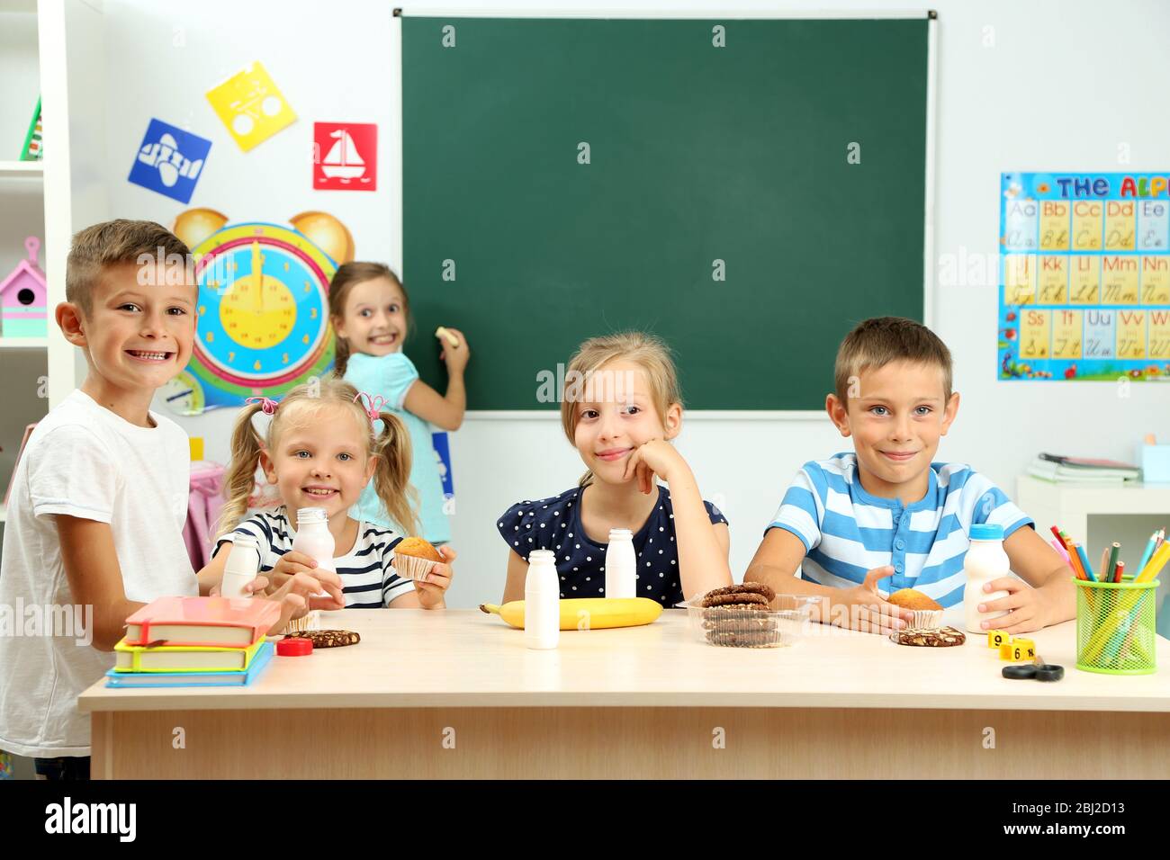 Cute children at lunch time in classroom Stock Photo - Alamy