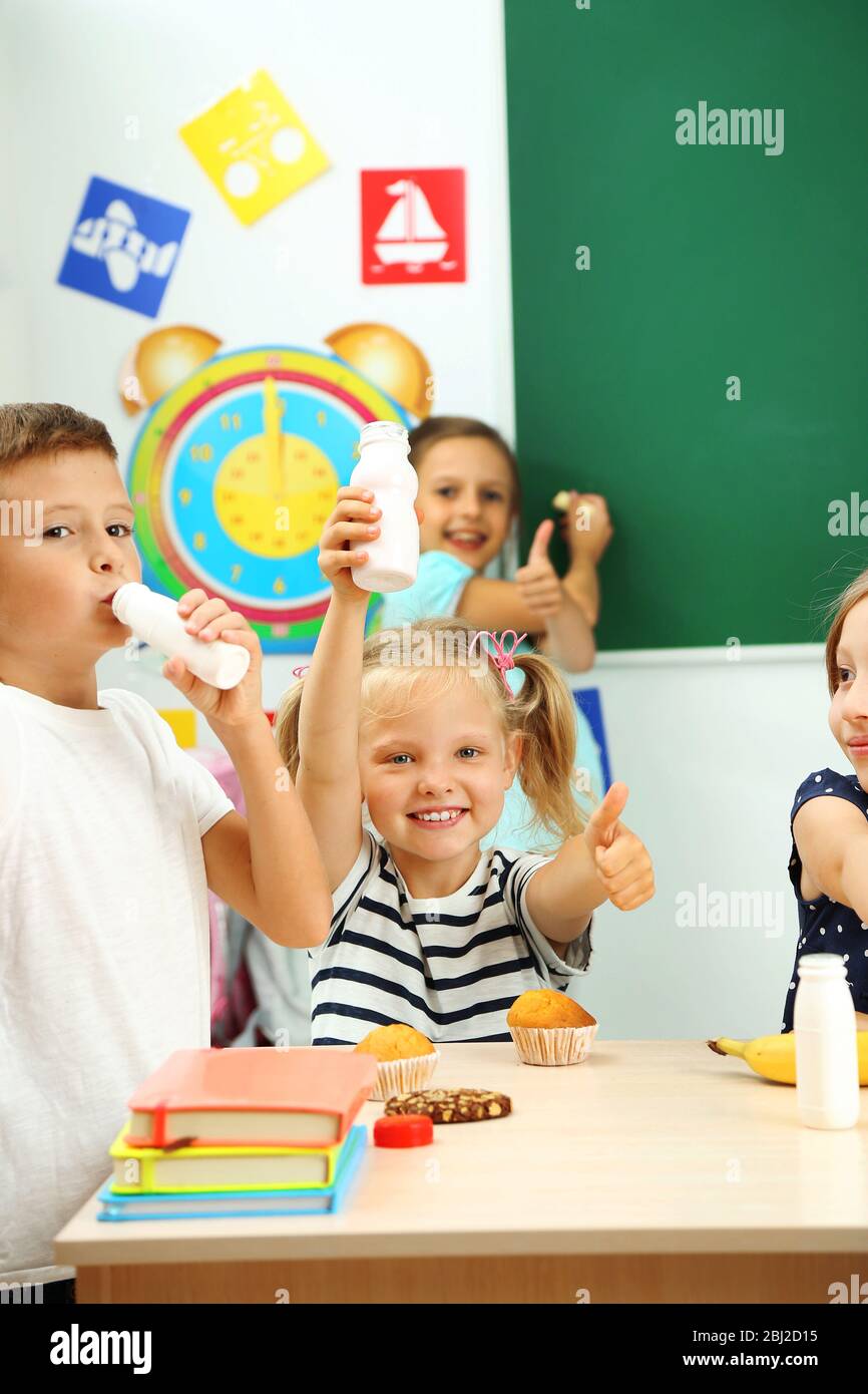 Cute children at lunch time in classroom Stock Photo - Alamy
