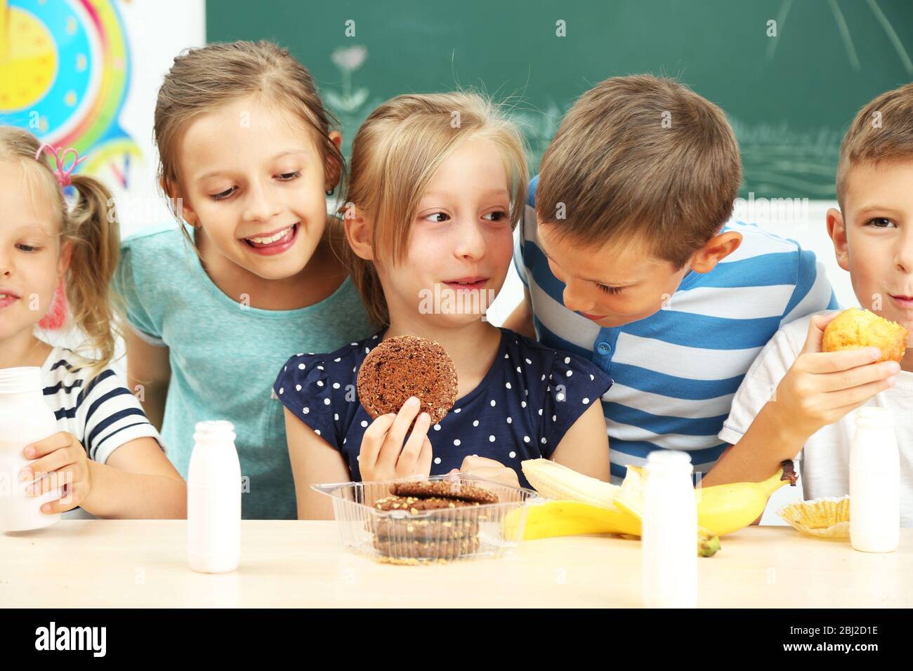 Cute children at lunch time in classroom Stock Photo - Alamy