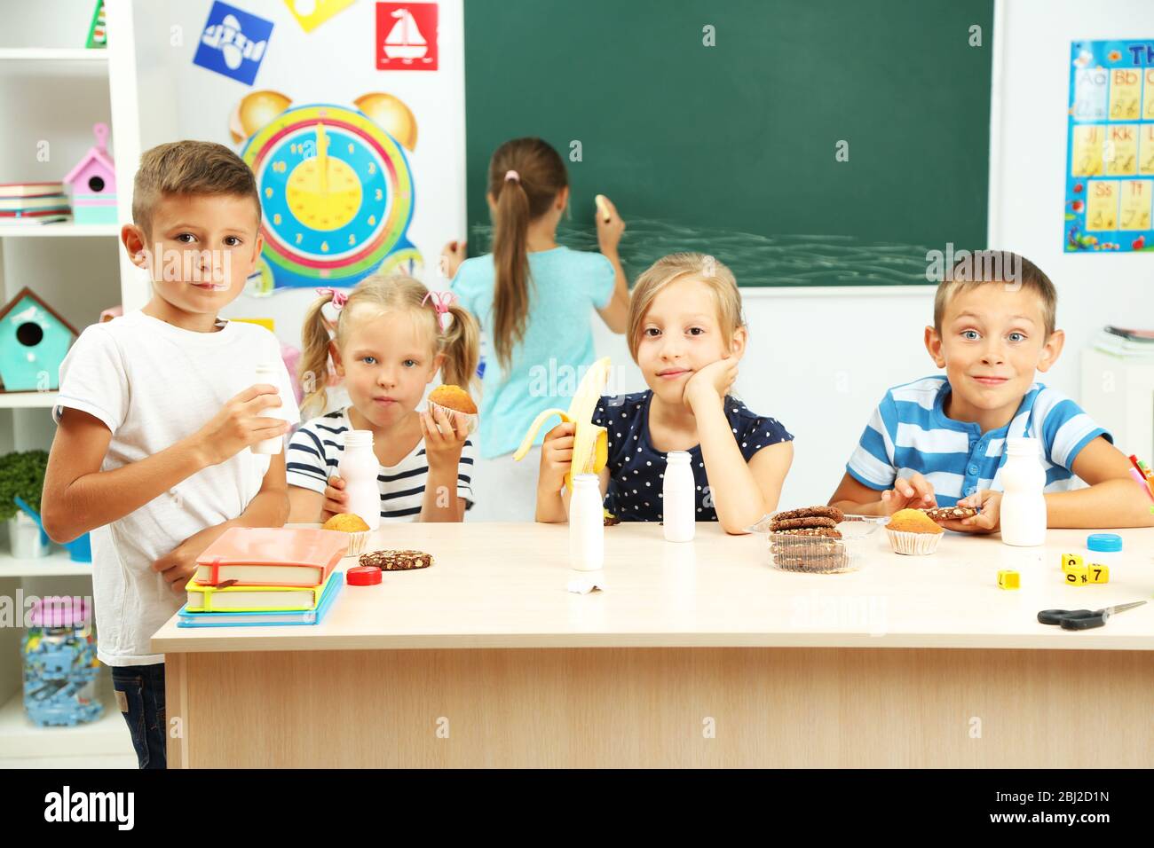 Cute children at lunch time in classroom Stock Photo - Alamy