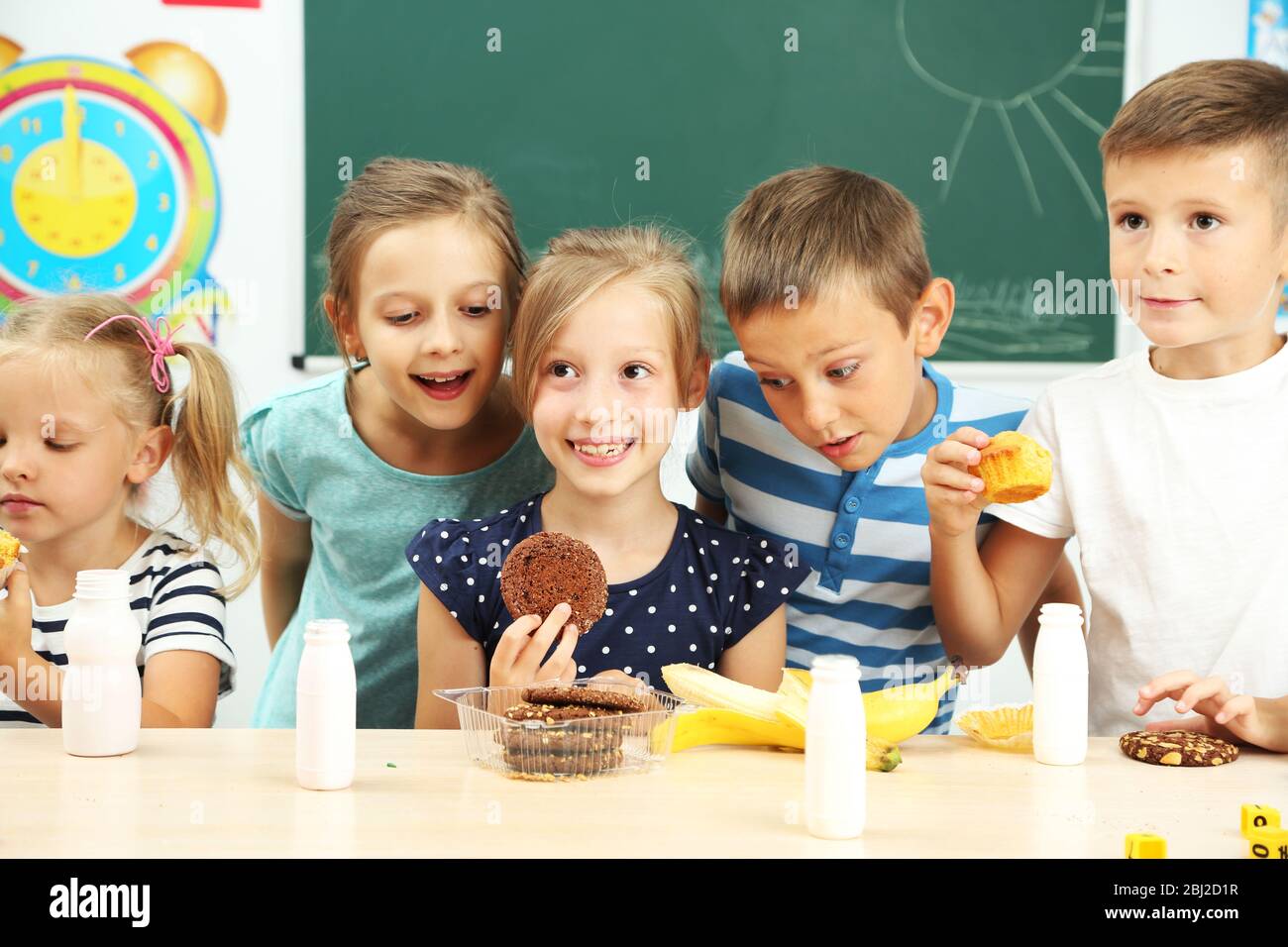 Cute children at lunch time in classroom Stock Photo - Alamy