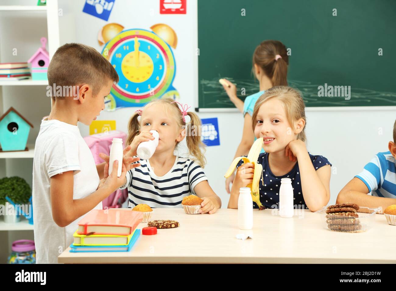 Cute children at lunch time in classroom Stock Photo - Alamy