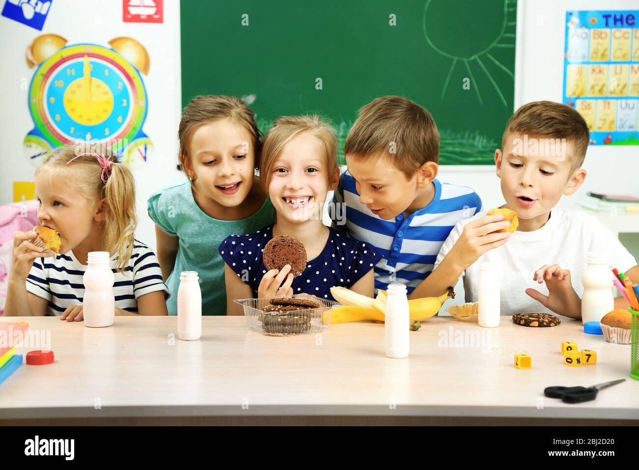 Cute children at lunch time in classroom Stock Photo - Alamy