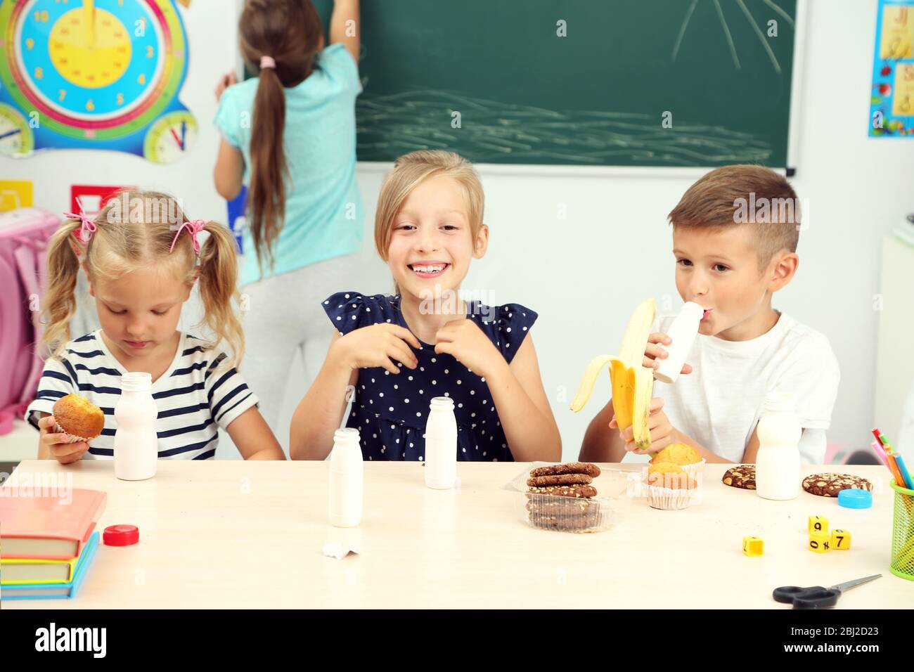 Cute children at lunch time in classroom Stock Photo - Alamy