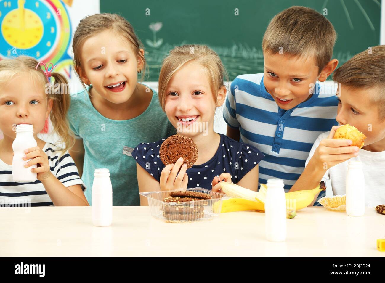 Cute children at lunch time in classroom Stock Photo - Alamy