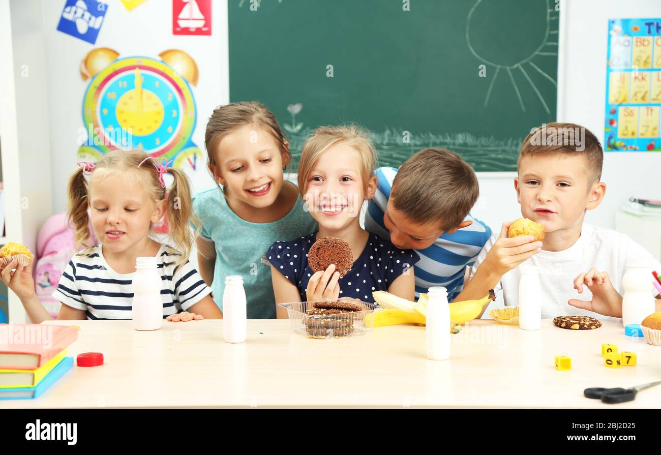 Cute children at lunch time in classroom Stock Photo - Alamy