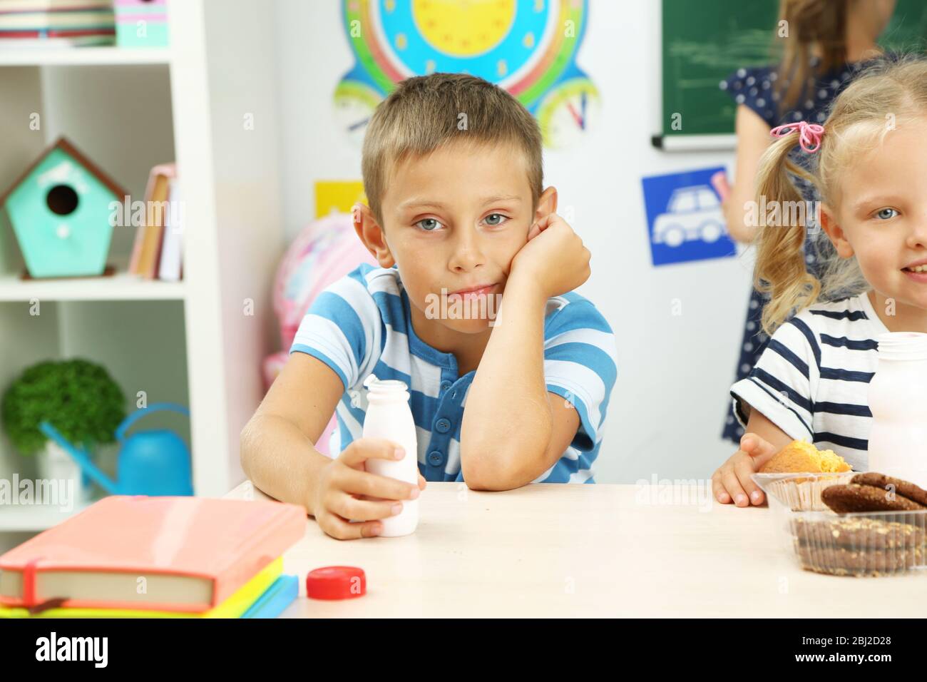 Cute children at lunch time in classroom Stock Photo - Alamy