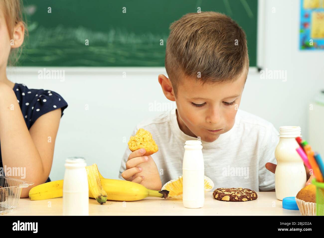 Cute children at lunch time in classroom Stock Photo - Alamy
