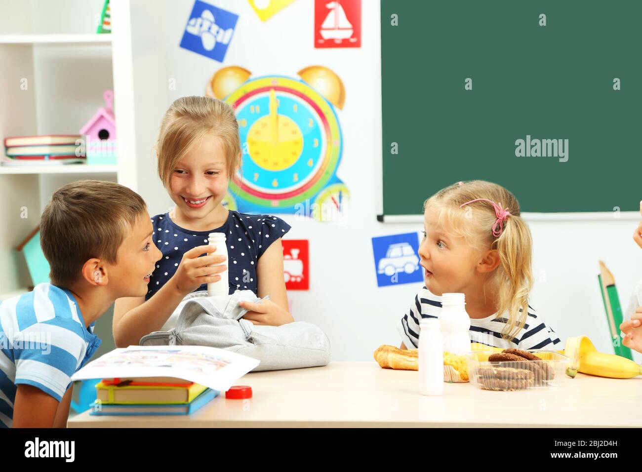 Cute children at lunch time in classroom Stock Photo - Alamy