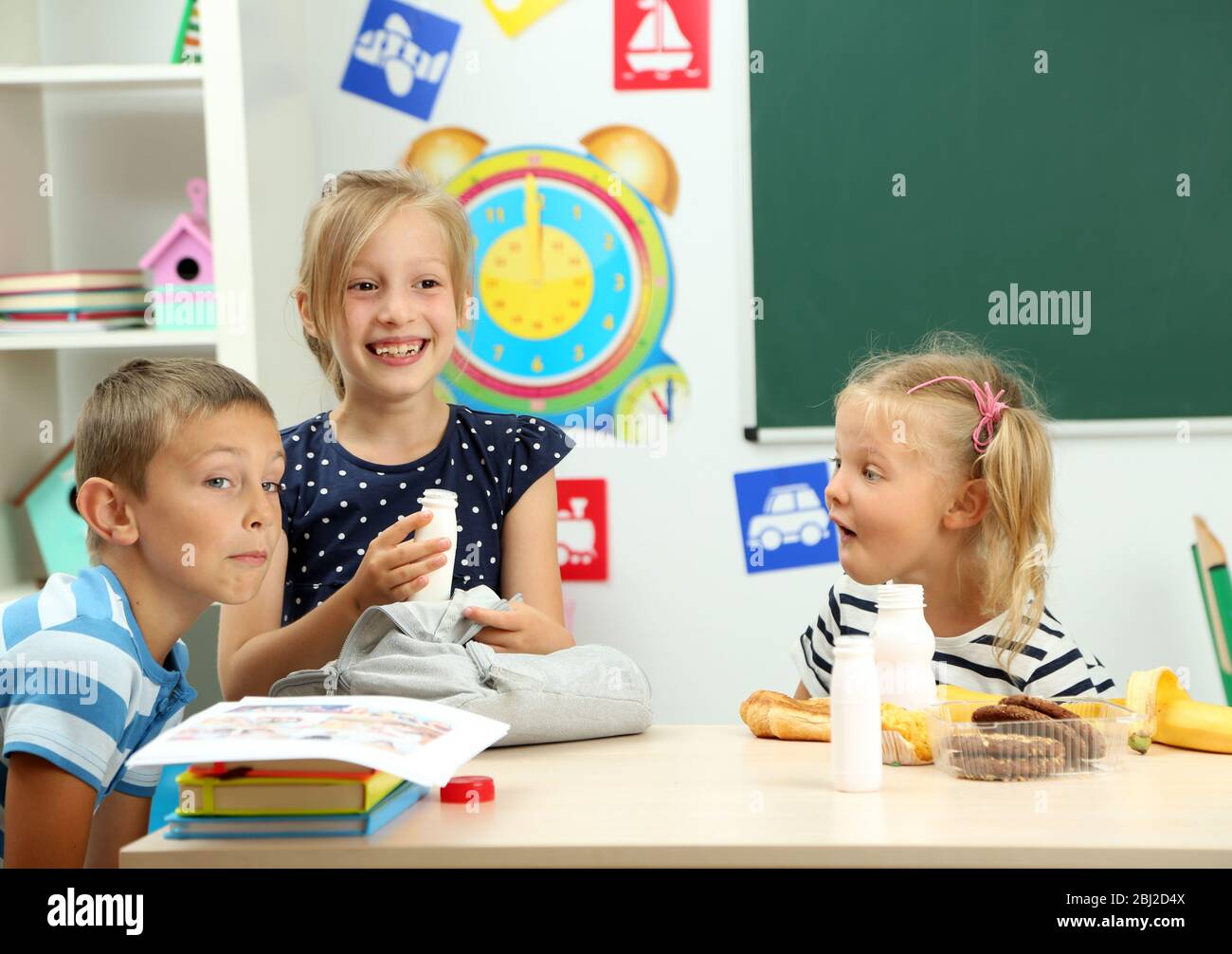 Cute children at lunch time in classroom Stock Photo - Alamy