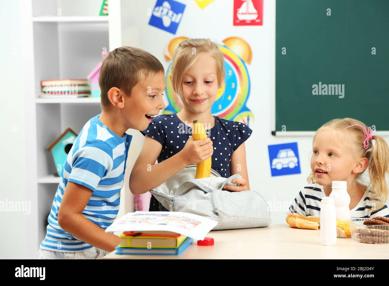 Cute children at lunch time in classroom Stock Photo - Alamy