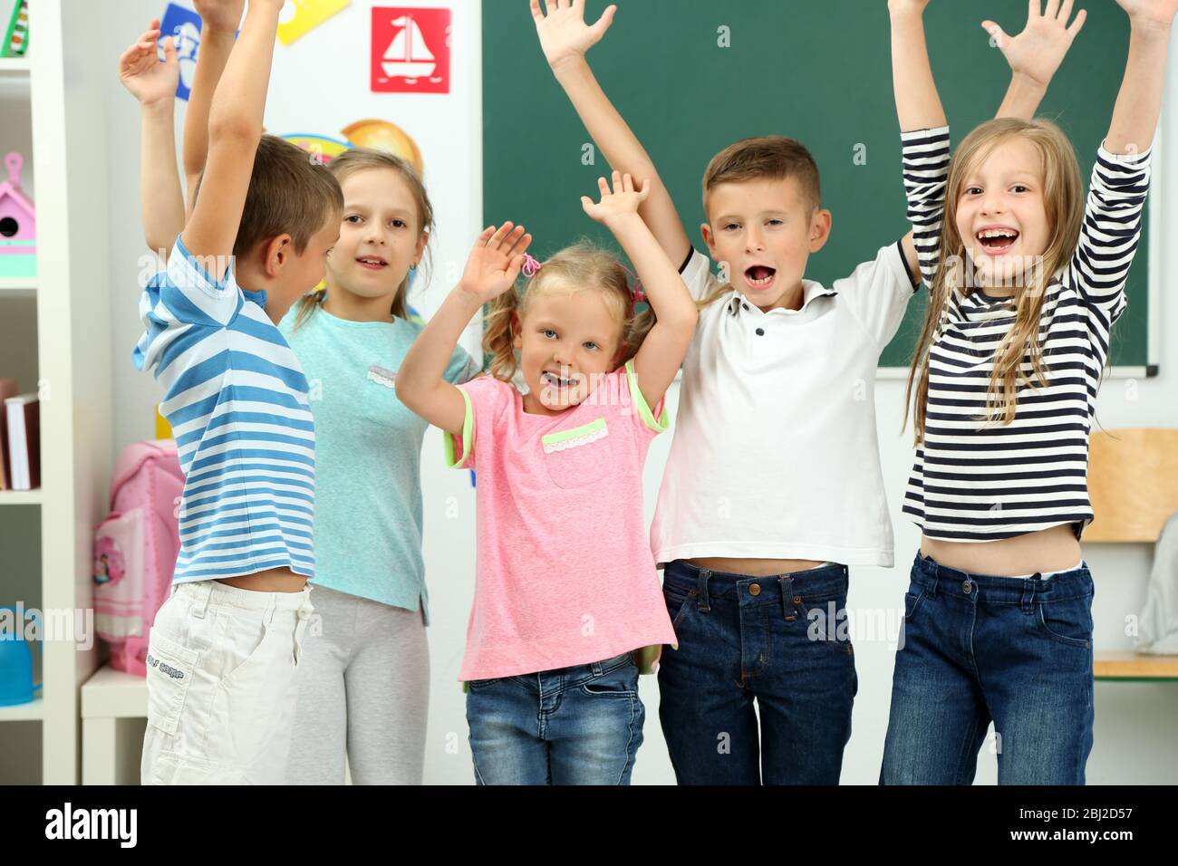Portrait of happy classmates looking at camera in classroom Stock Photo ...