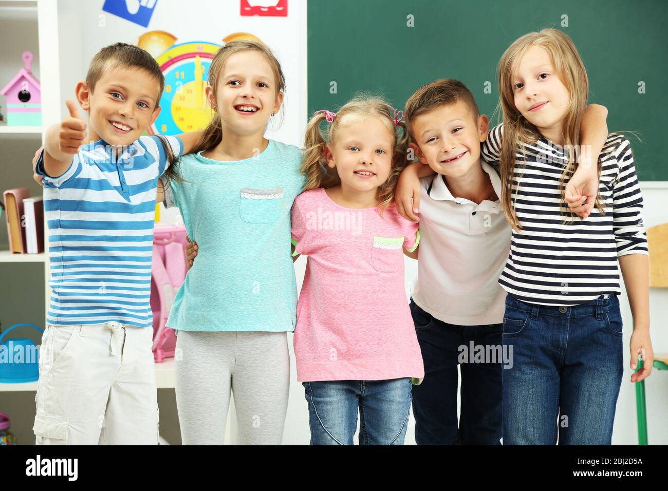 Portrait of happy classmates looking at camera in classroom Stock Photo ...