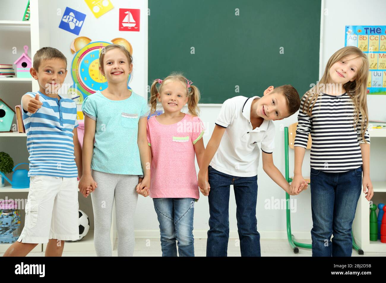 Portrait of happy classmates looking at camera in classroom Stock Photo ...