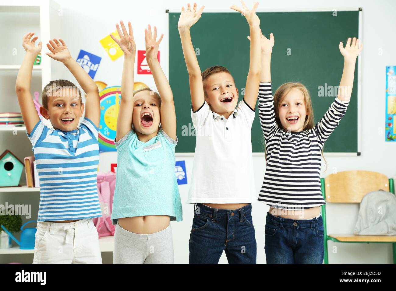 Portrait of happy classmates looking at camera in classroom Stock Photo ...