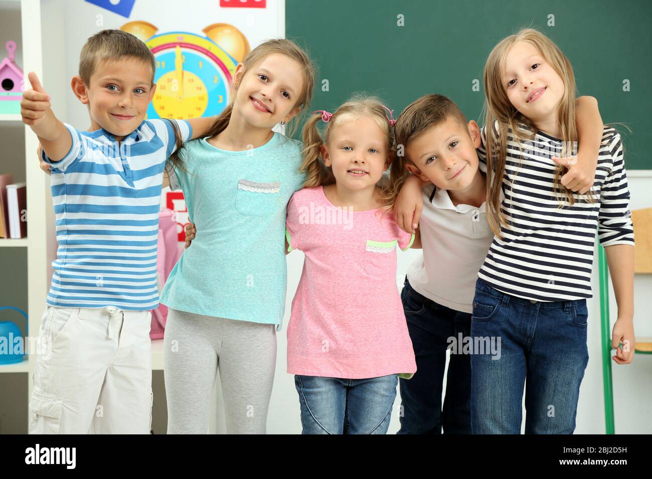Portrait of happy classmates looking at camera in classroom Stock Photo ...