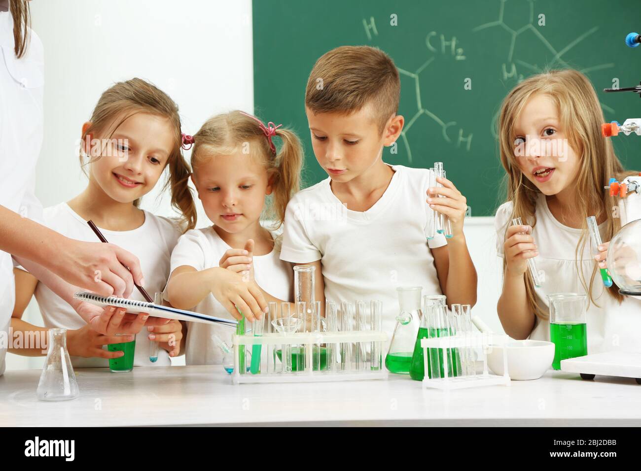 Cute pupils with teacher doing biochemistry research in chemistry class ...
