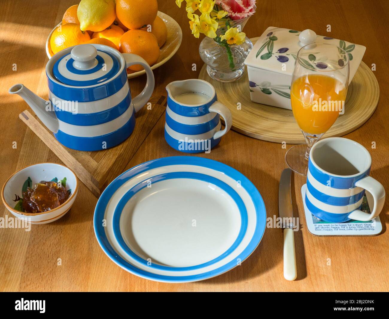 Wooden kitchen table laid with Cornishware service Stock Photo - Alamy