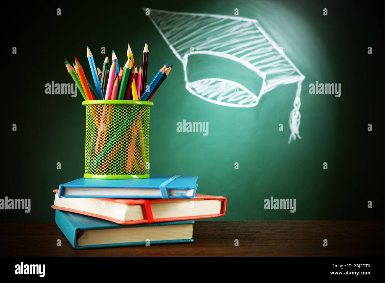 Metal cap of crayons, stack pf books and bachelor hat drawing on ...