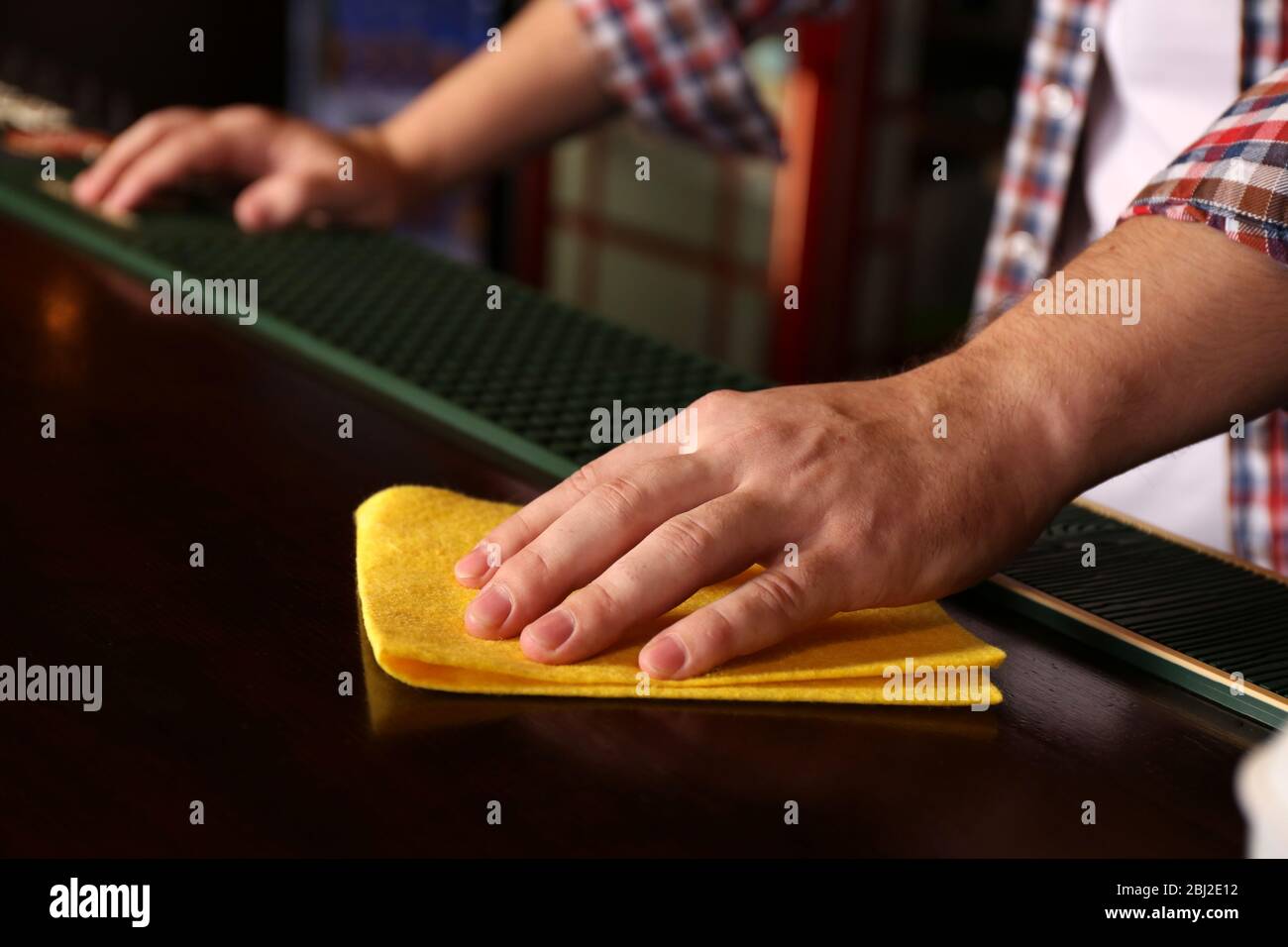 Bartender wiping down bar counter Stock Photo - Alamy