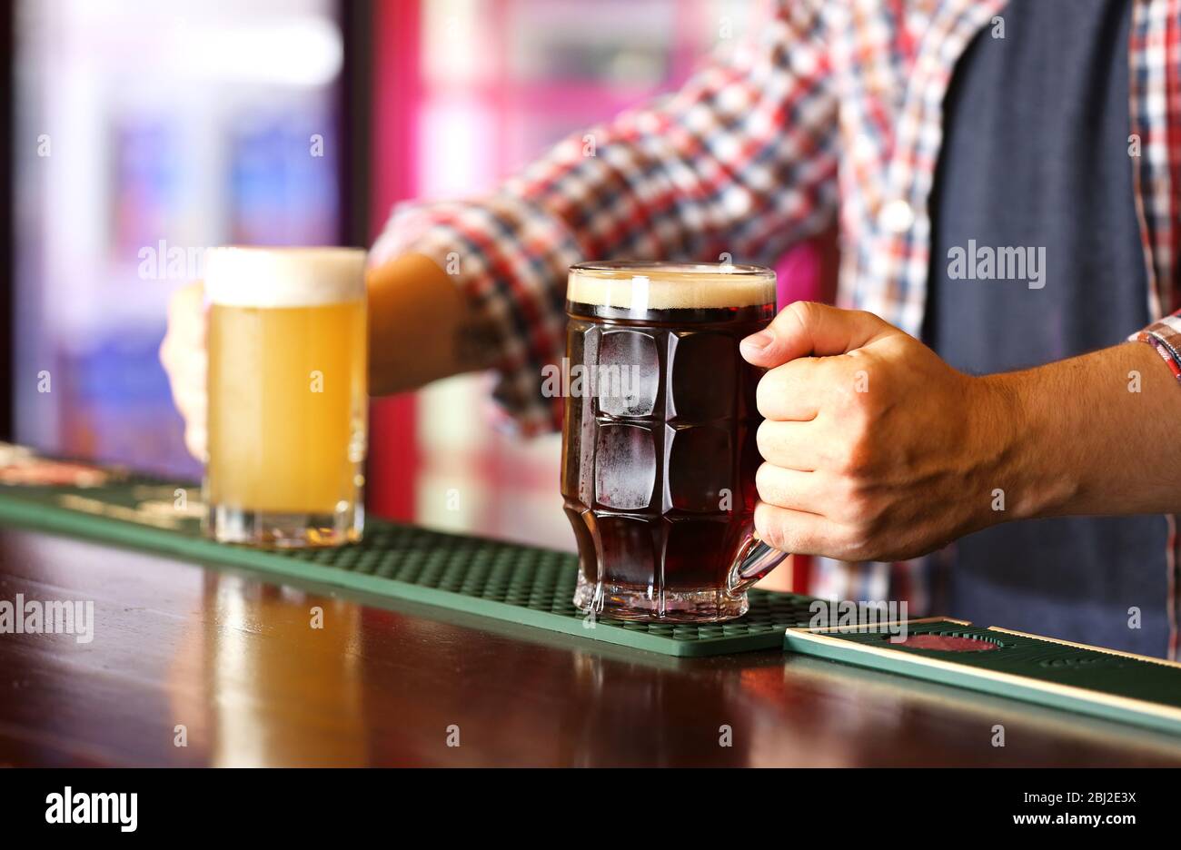 Bartender holding beer glass at workplace Stock Photo - Alamy