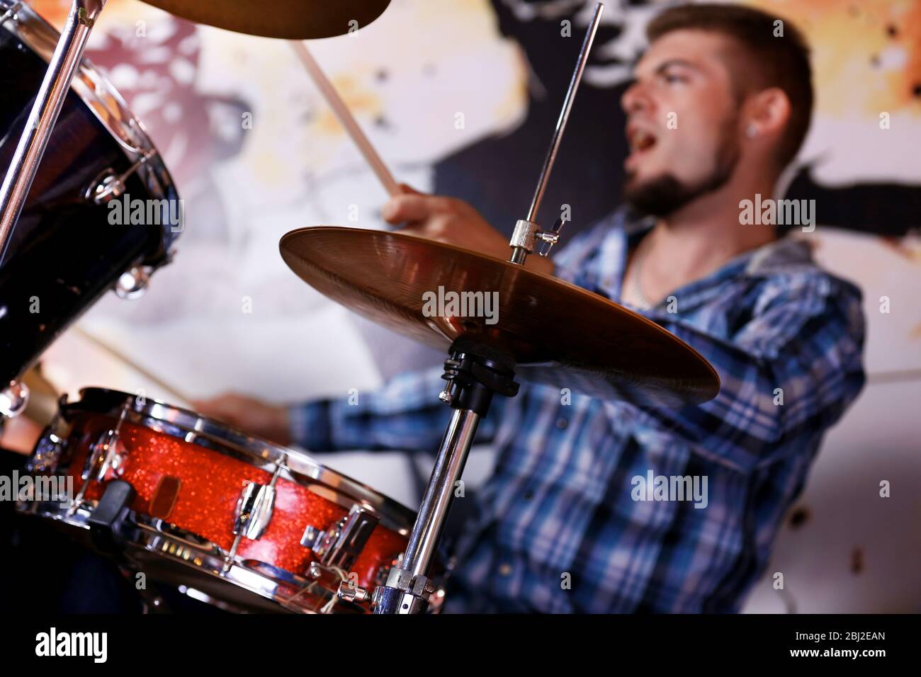 Excited drummer on bright background Stock Photo - Alamy