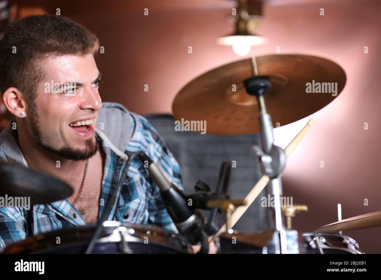 Excited drummer on bright background Stock Photo - Alamy