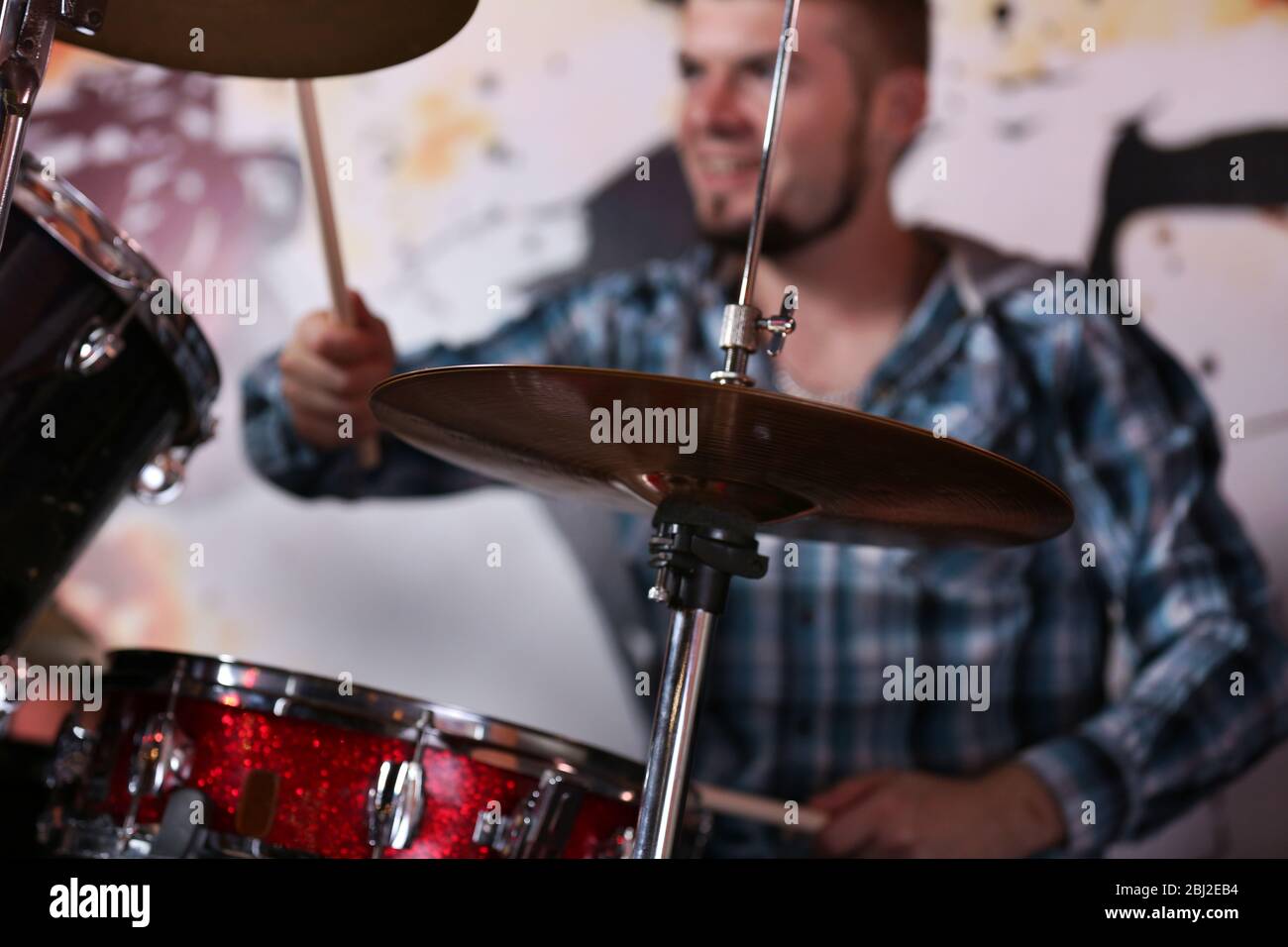 Excited drummer on bright background Stock Photo - Alamy