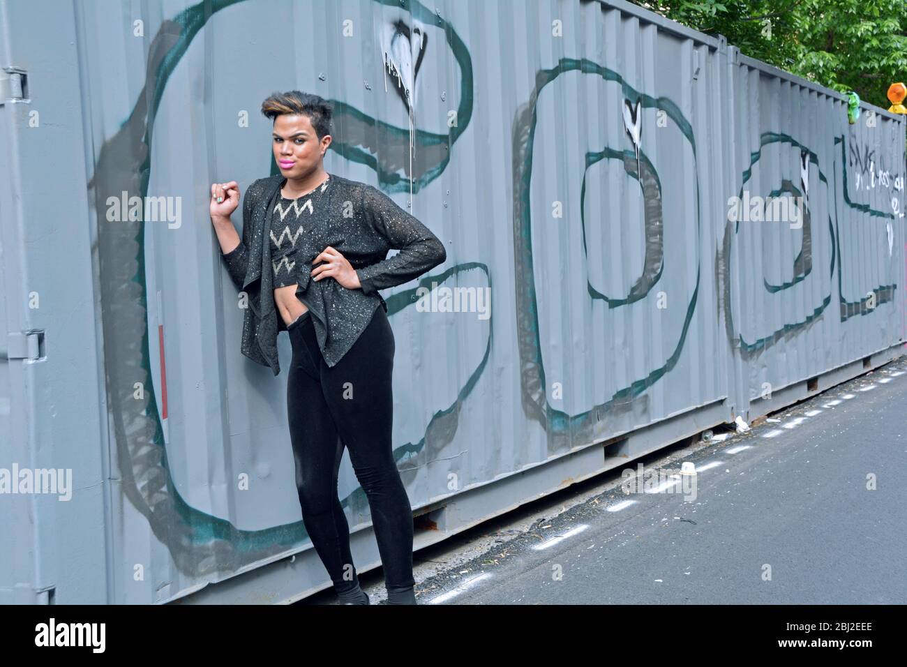 A teenage transitioning trans girl poses for a photo in front of a sign ...