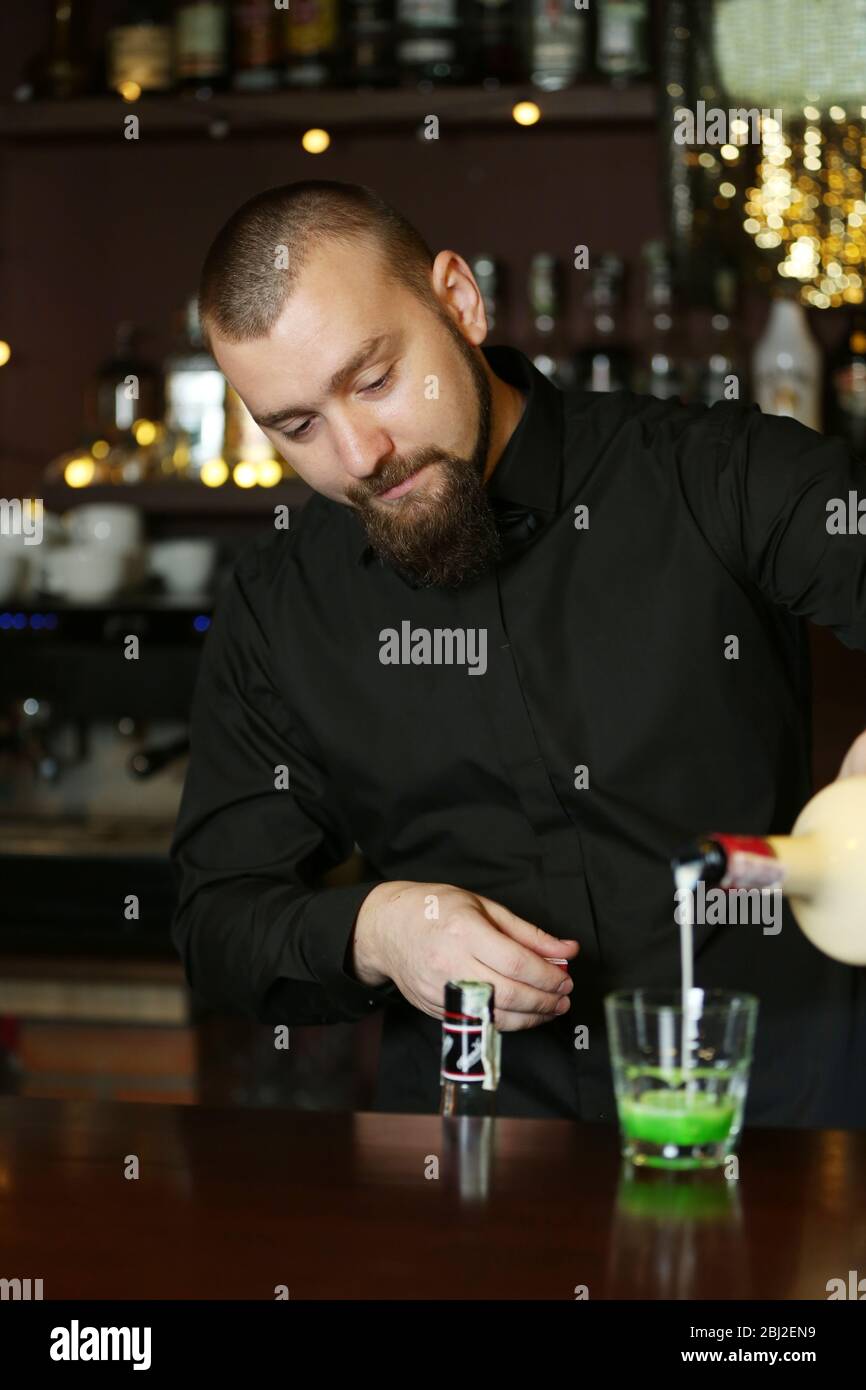 Bartender is pouring liquor into glass Stock Photo - Alamy