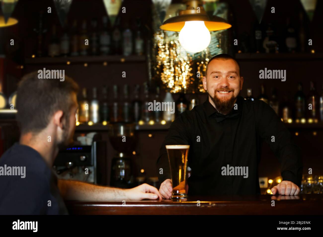 Young man drinking beer in bar Stock Photo - Alamy