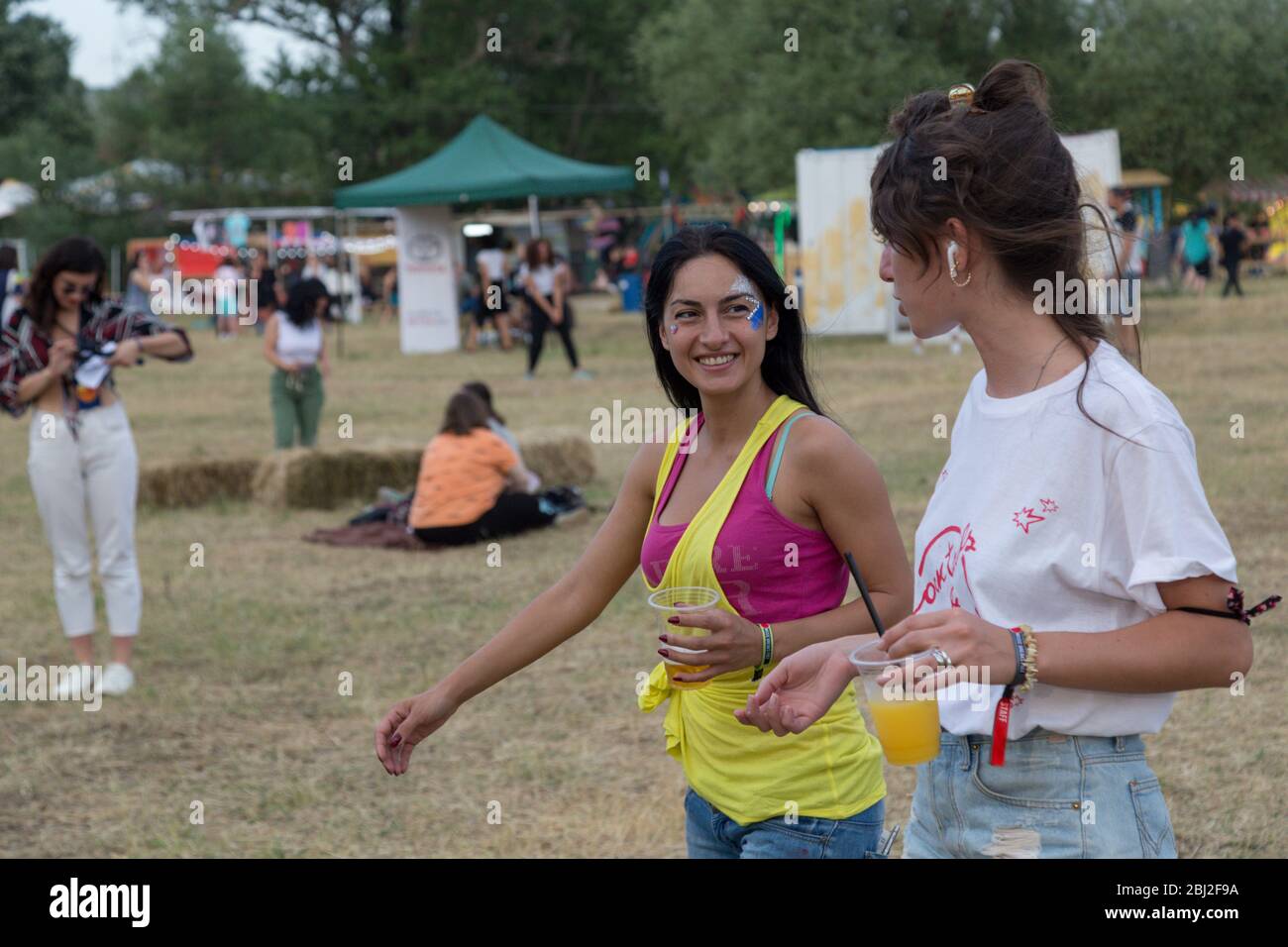 Audience with hands raised at a music festival and lights streaming ...