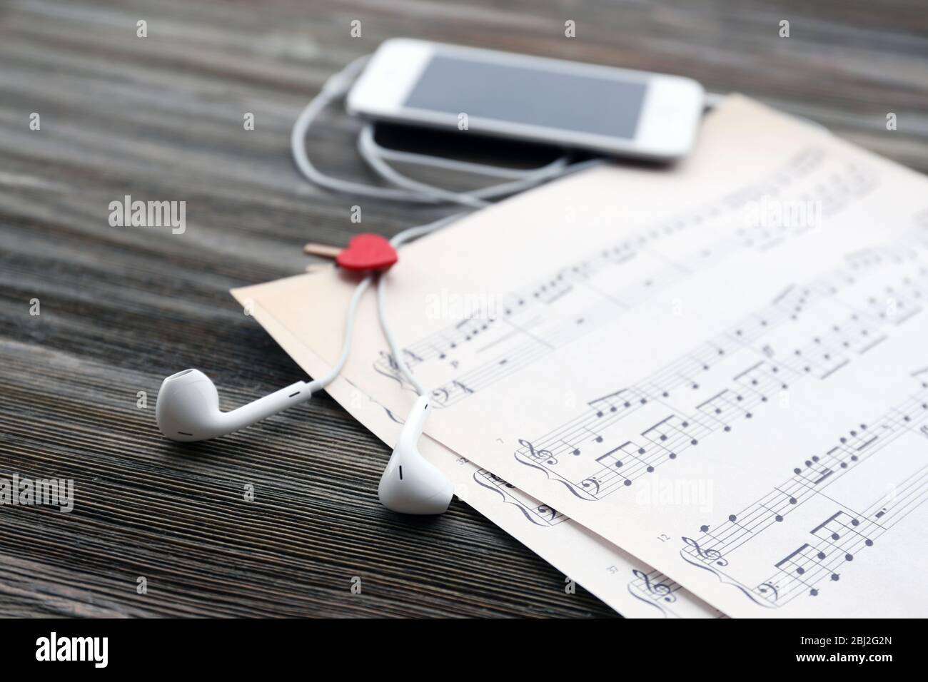 Mobile phone and earphones with music notes on wooden background Stock ...