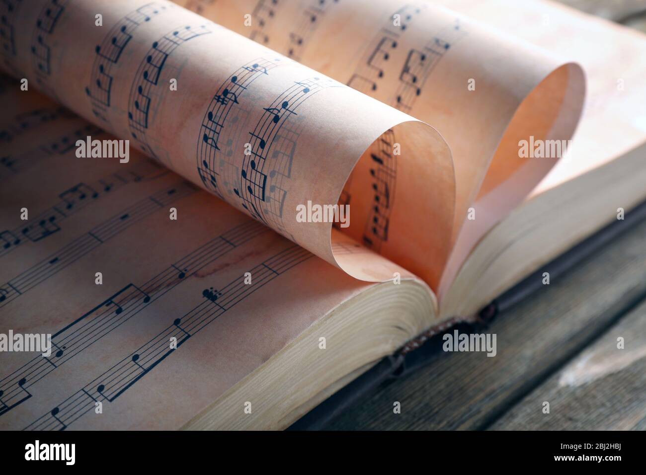Book pages curved into heart shape close up Stock Photo - Alamy