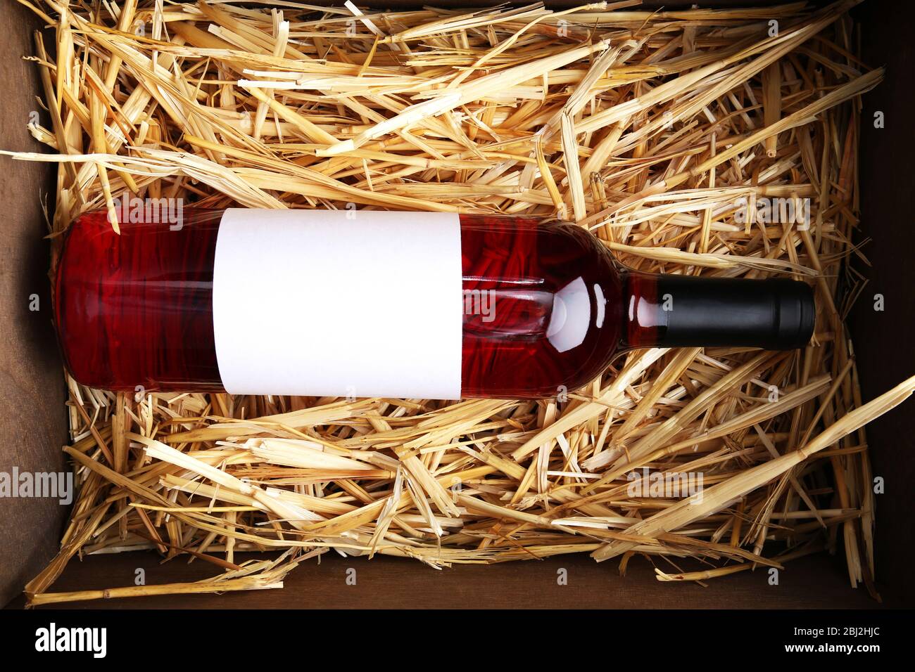 Wine bottle in the box with straw Stock Photo - Alamy