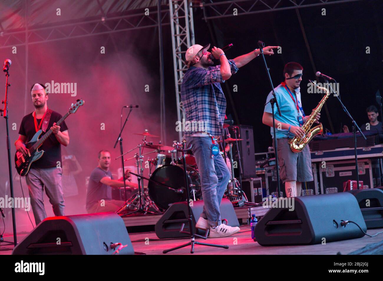 Audience with hands raised at a music festival and lights streaming ...