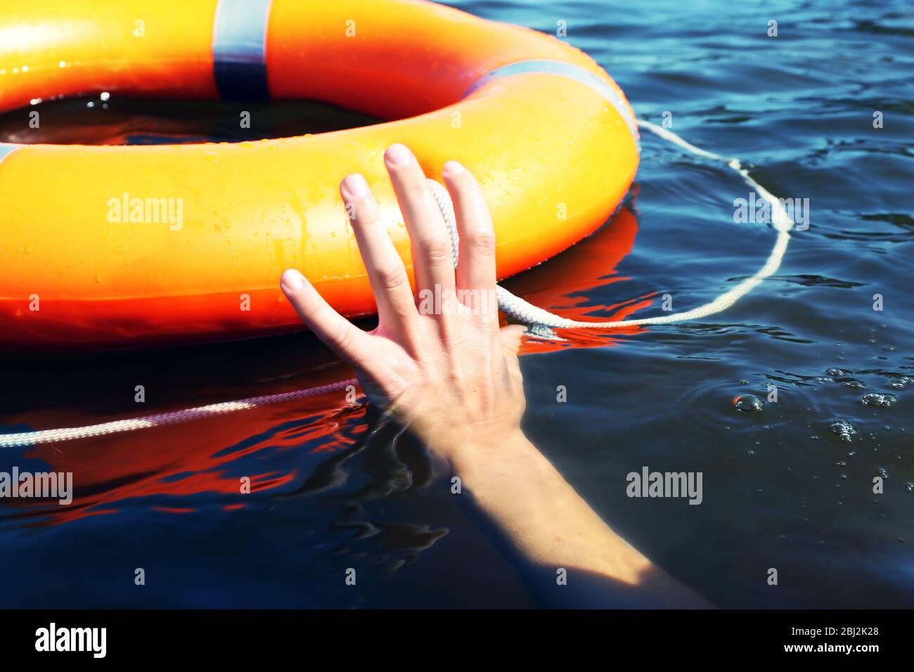 Hand trying to hold life buoy Stock Photo - Alamy