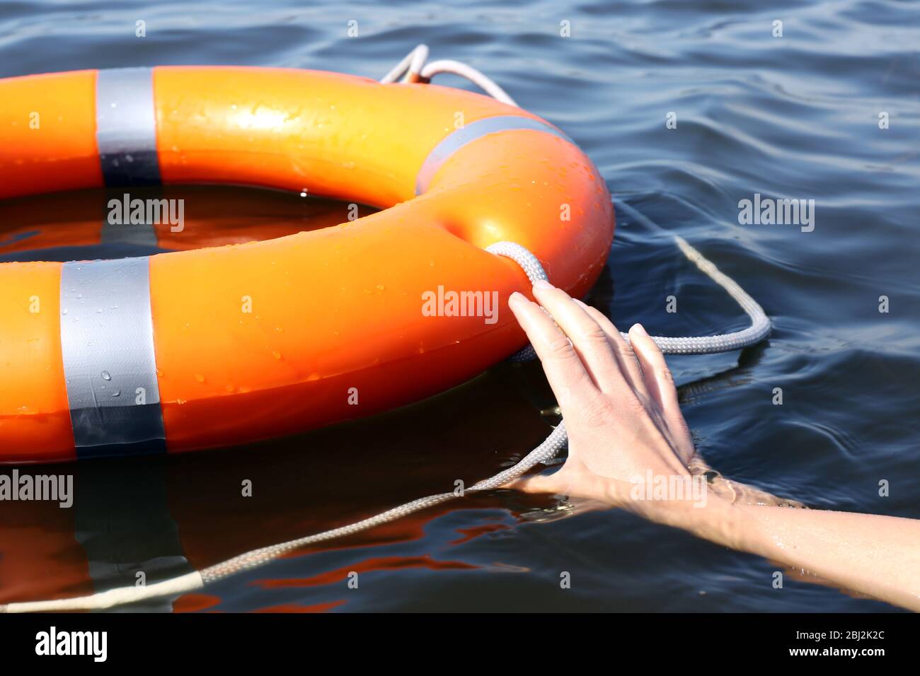 Hand trying to hold life buoy Stock Photo - Alamy
