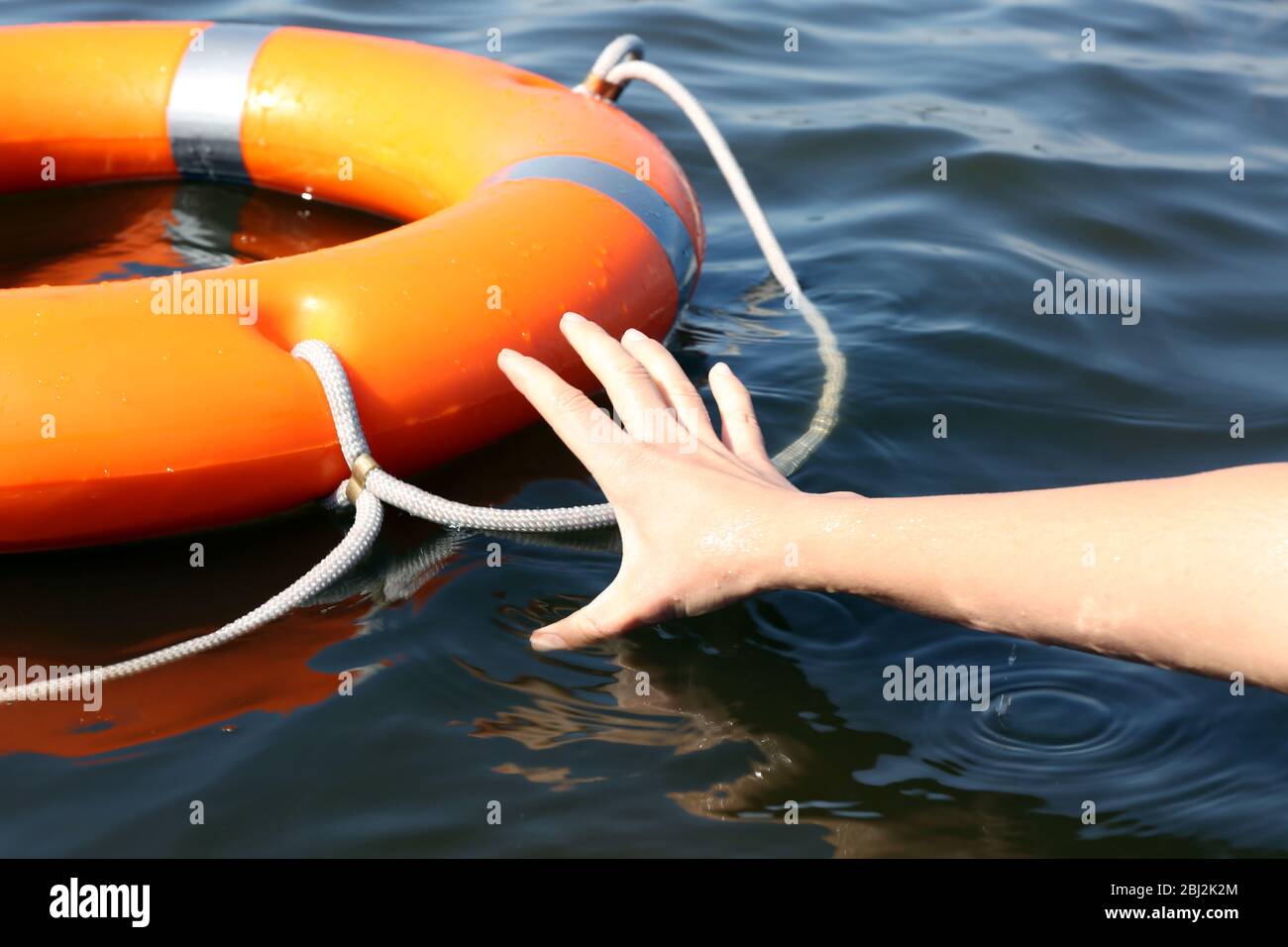 Hand trying to hold life buoy Stock Photo - Alamy