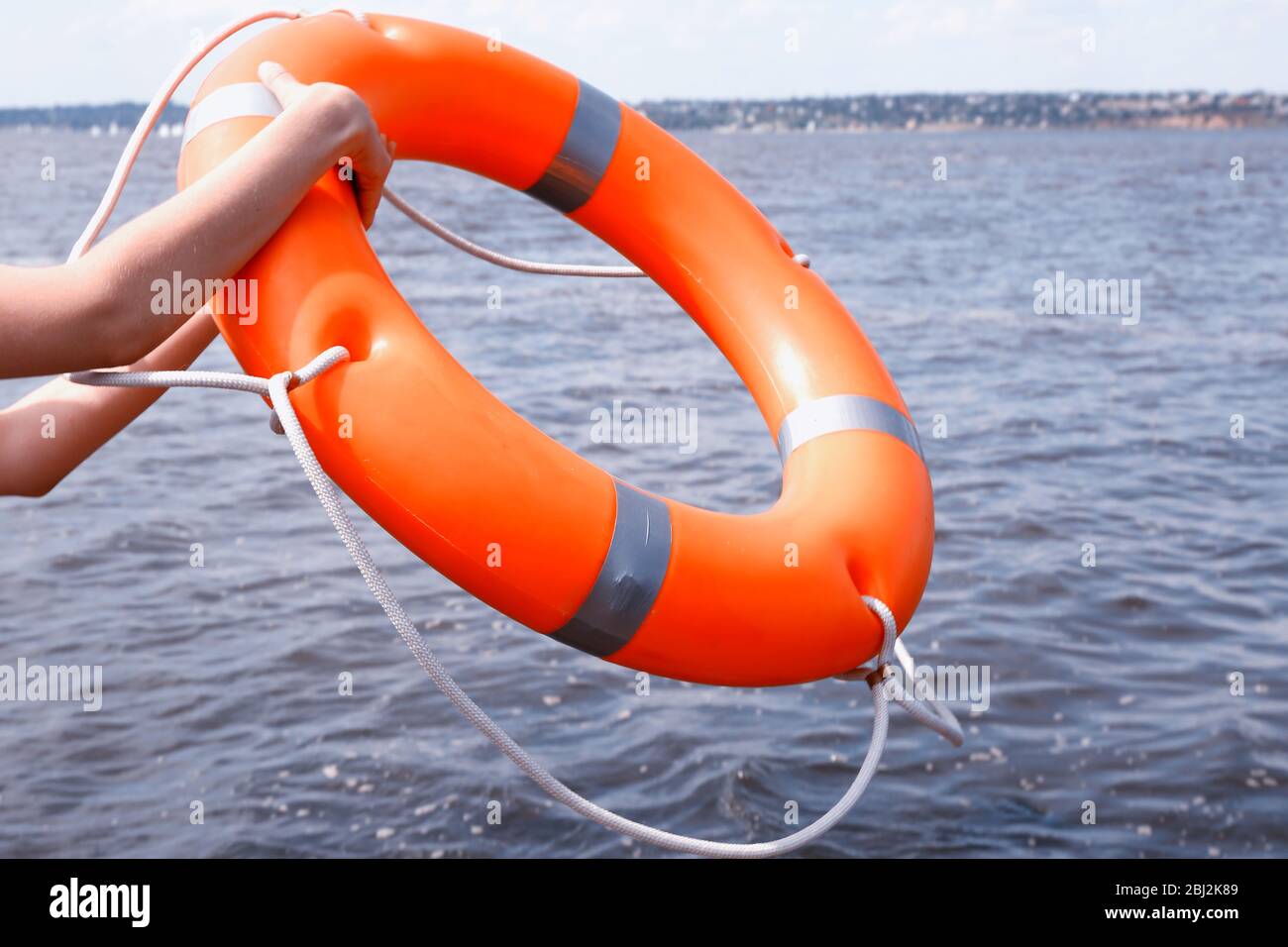Hands going on to throw a life buoy to the water Stock Photo - Alamy